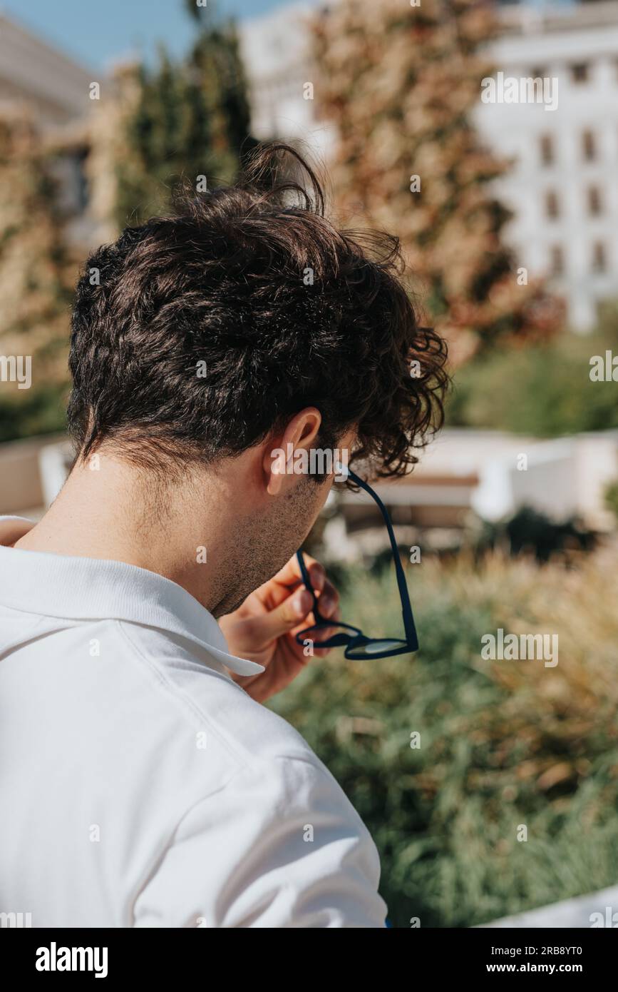 Back view photo of businessman putting eyeglasses on Stock Photo - Alamy