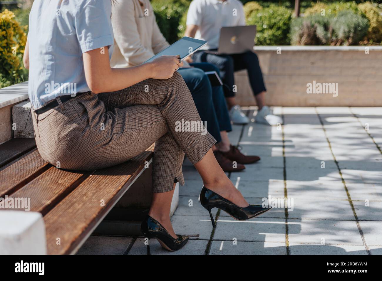 Business people sitting on a bench. Remote work concept Stock Photo - Alamy