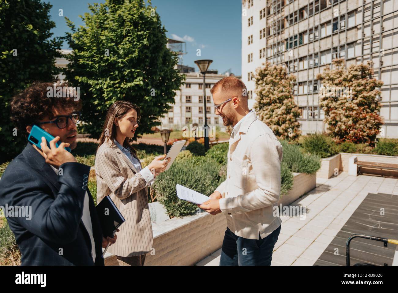 Smart, young, professional architects working outdoors, discussing ...