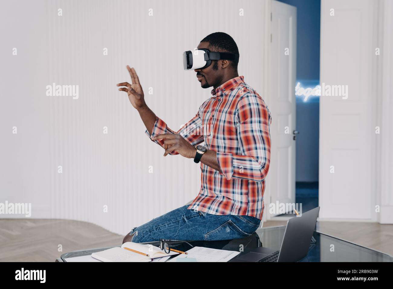 Modern african american guy wearing VR glasses interacts with augmented ...
