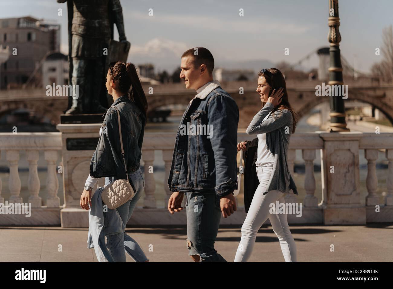 Three friends walking while one of them is talking and explaining ...