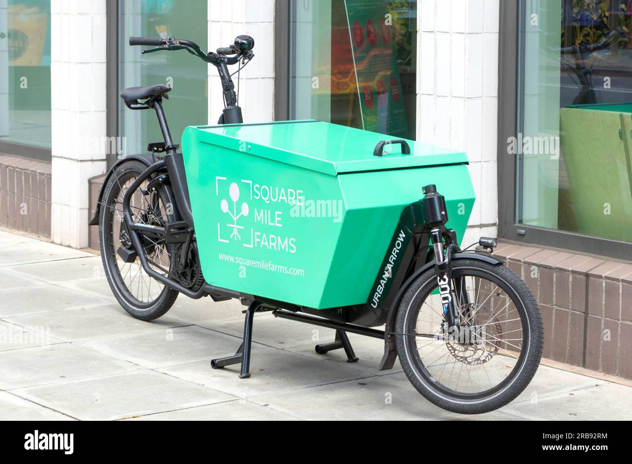 green urban arrow cargo bike with square mile farms branding in a ...