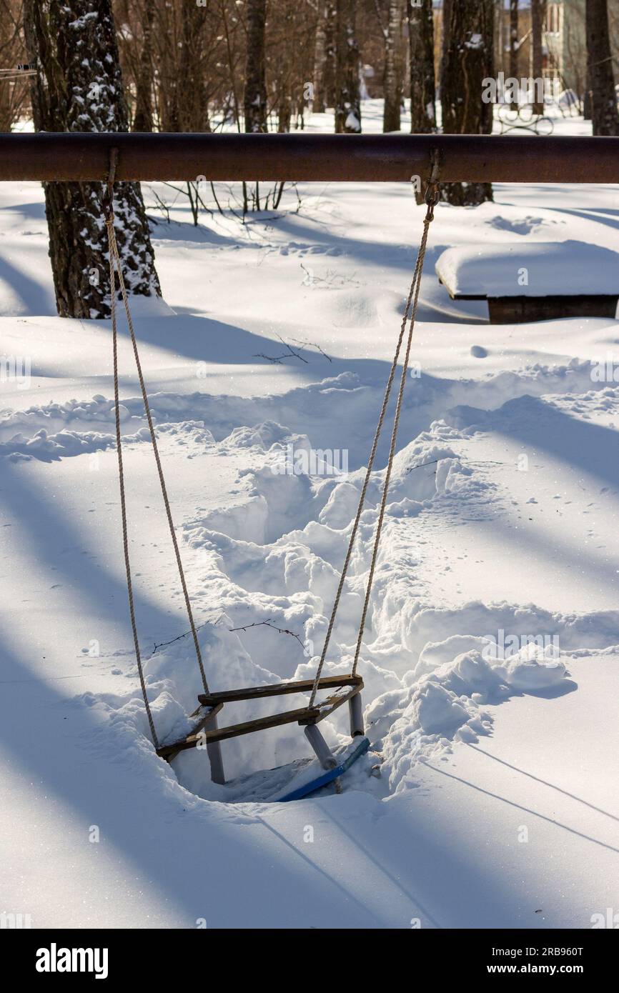 Children's playground with swings covered with snow in winter Stock ...