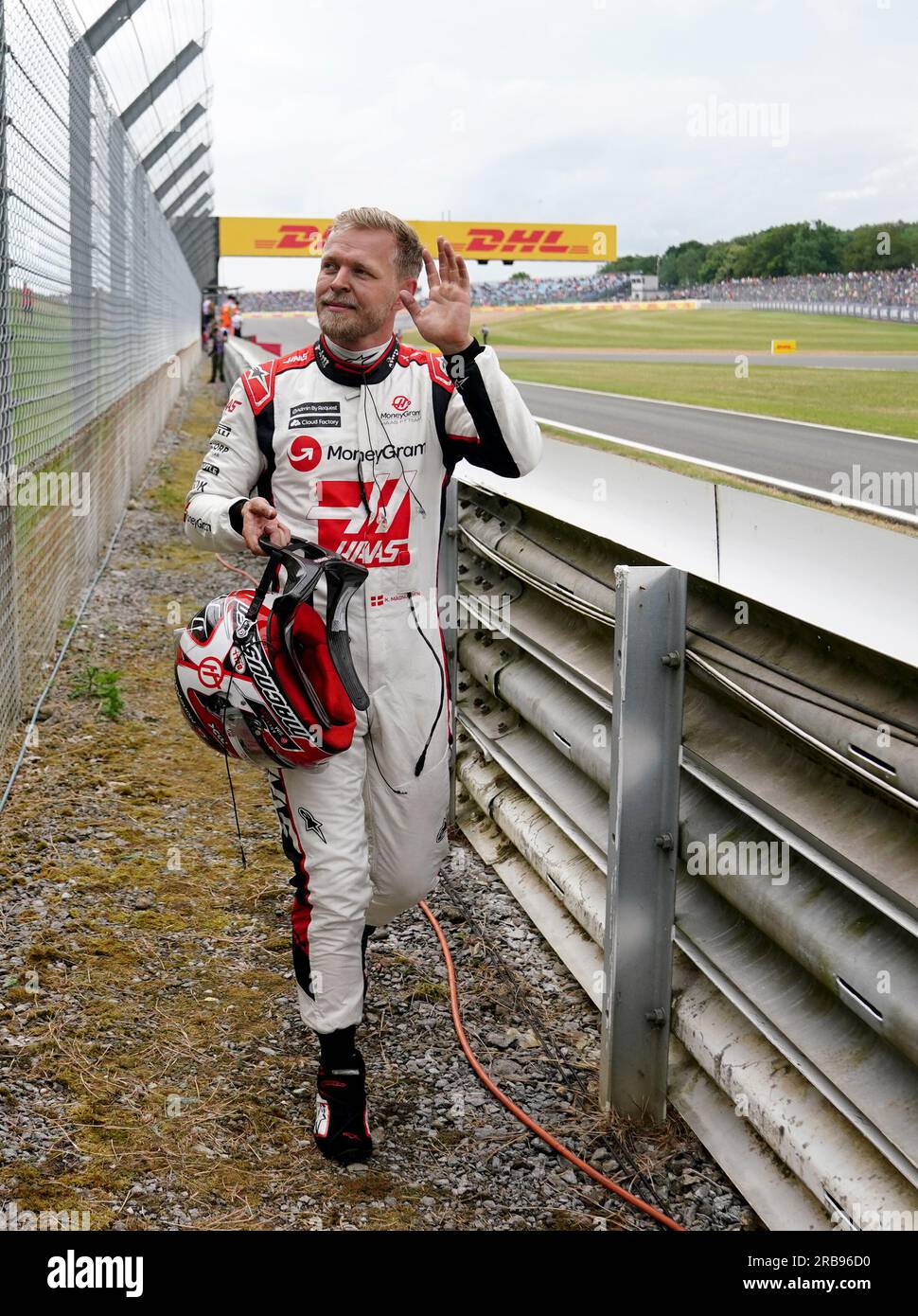 Haas' Kevin Magnussen makes his way back to the pits after suffering a ...