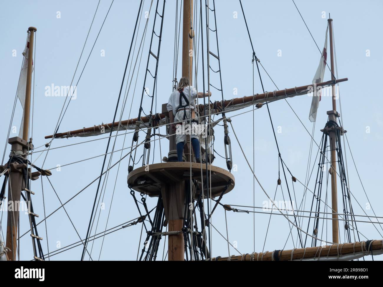 Sailor on lookout deck after climbing the rigging of replica sailing ...