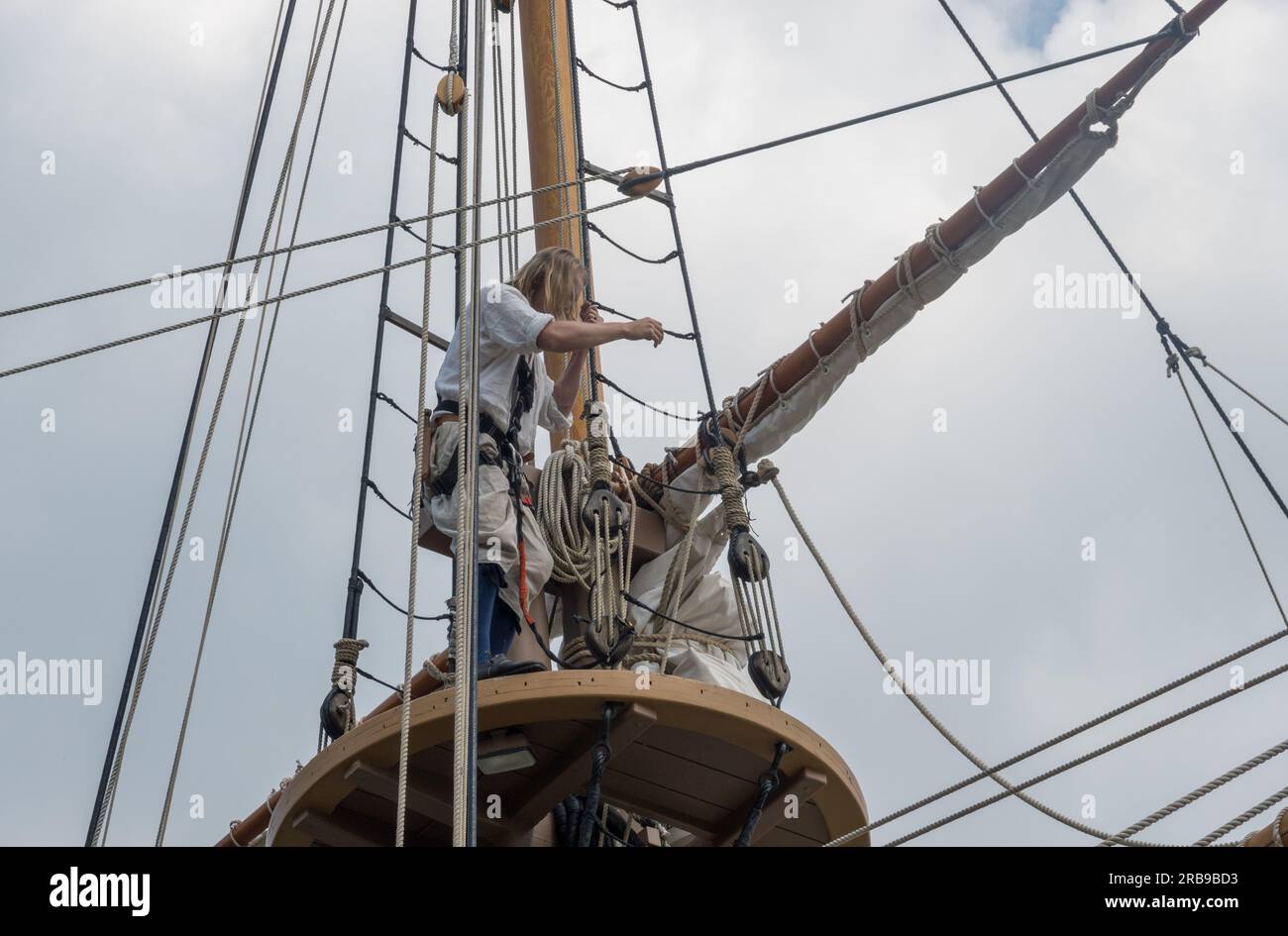 Sailor on lookout deck after climbing the rigging of replica sailing ...