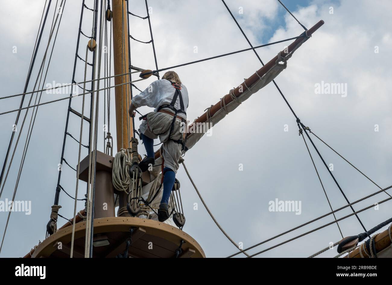 Sailor on lookout deck after climbing the rigging of replica sailing ...