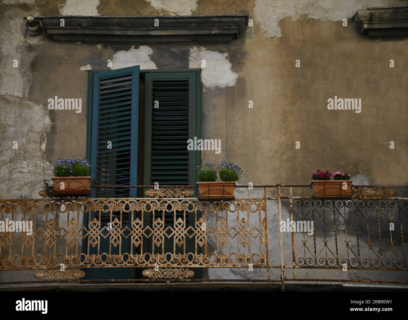 Old Neoclassical house with a weathered stucco wall, green wooden ...