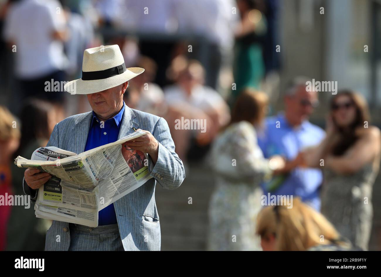 A racegoers reads a racing pull-out during Coral-Eclipse day of the ...
