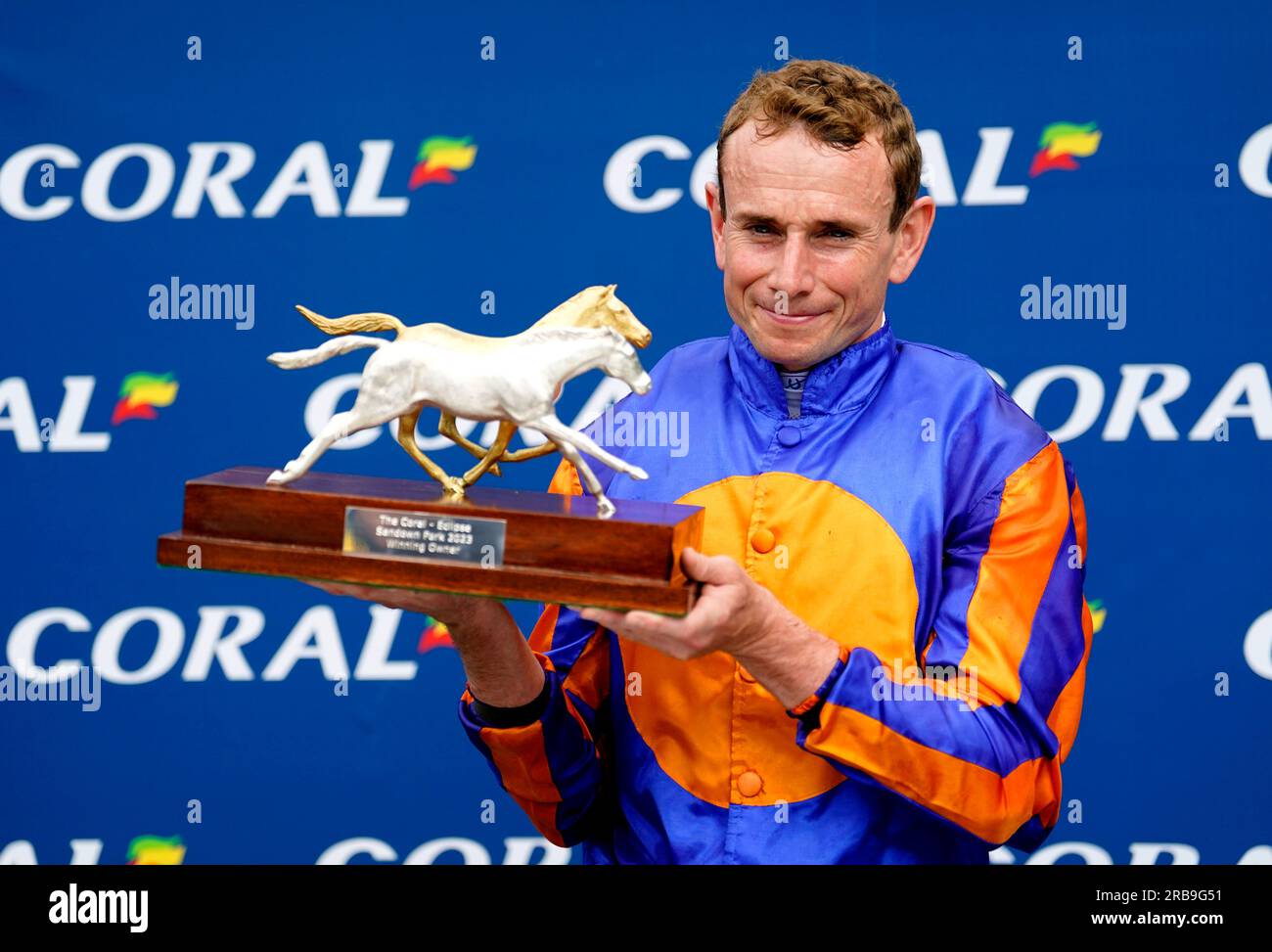 Jockey Ryan Moore poses for a photo with the trophy after winning the ...