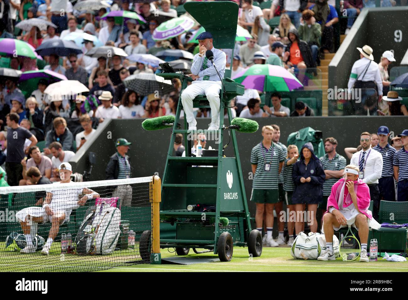 Holger Rune (left) and Davidovich Fokina under umbrellas on court 3 on ...