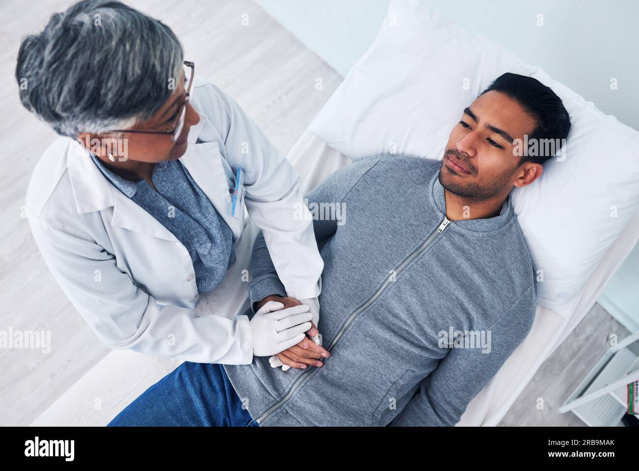 Sick, above and doctor holding hands with a man in a hospital for ...