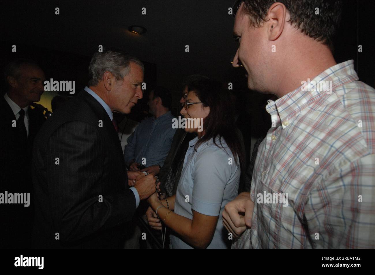 Department staff greeting President George W. Bush, from behind rope ...
