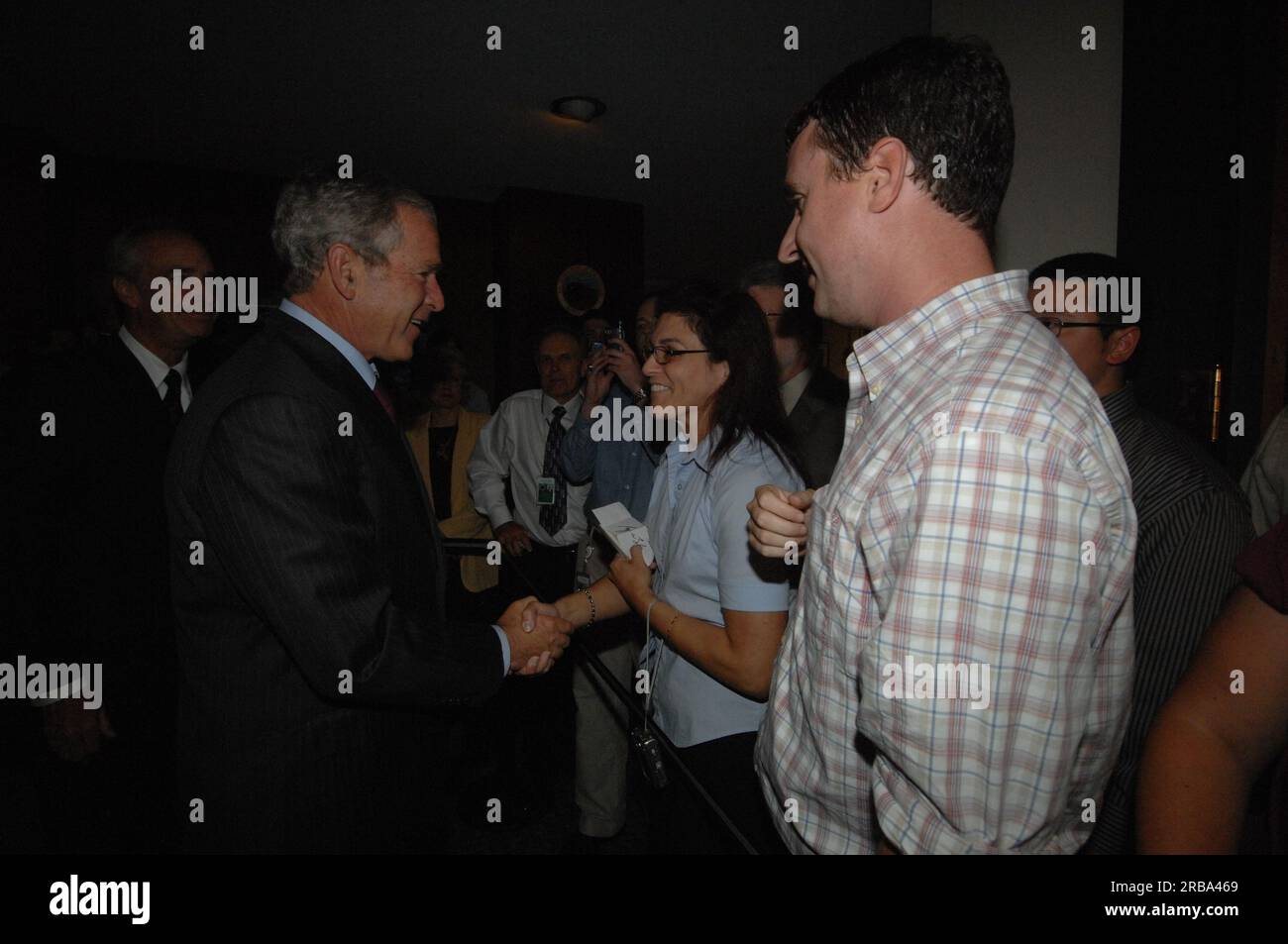 Department staff greeting President George W. Bush, from behind rope ...