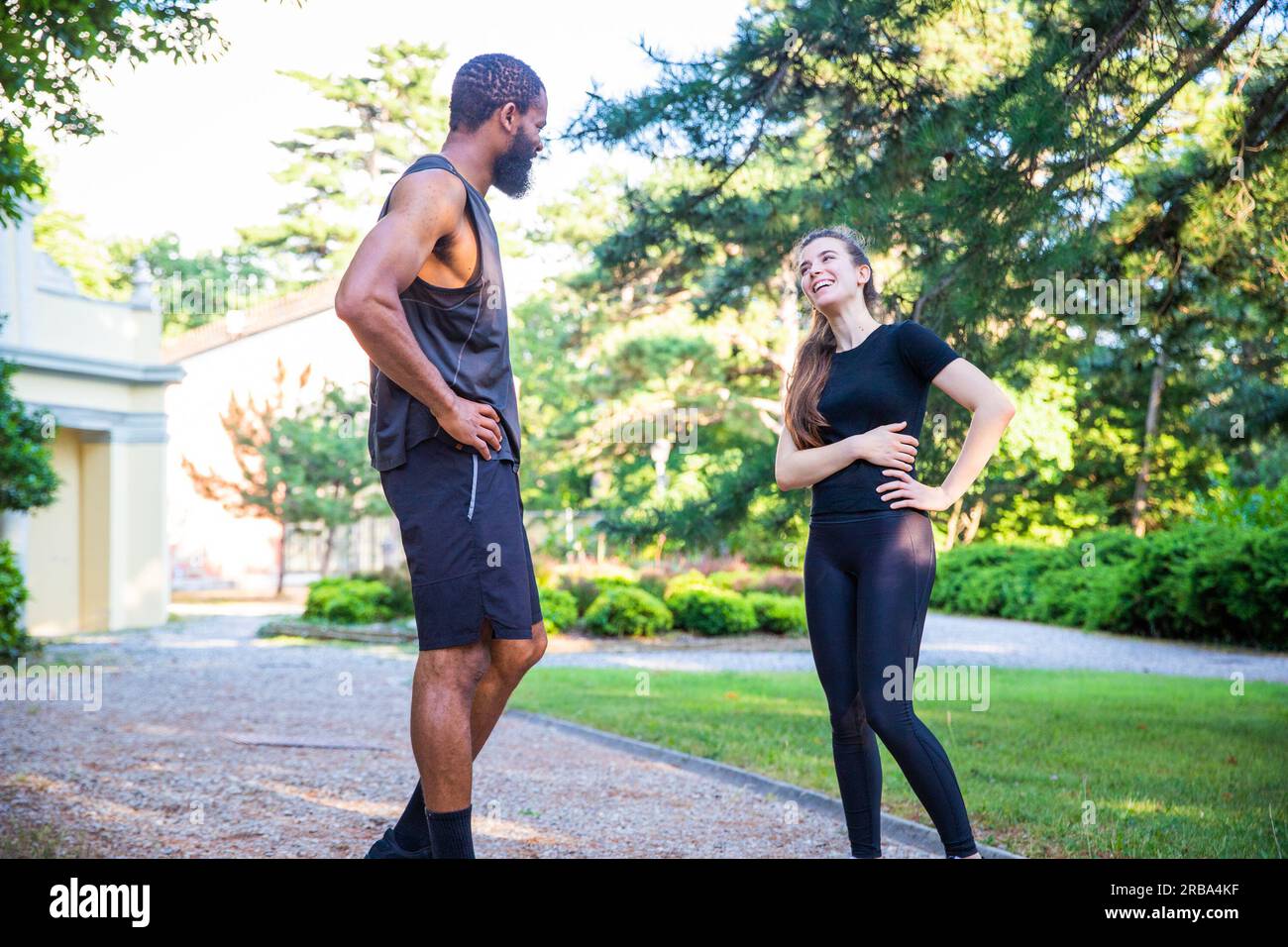 Two runners have a conversation during an outdoor workout, multi ethnic ...