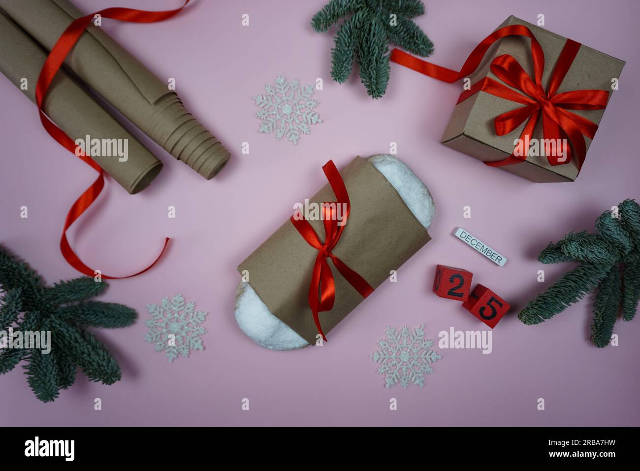 The stollen wrapped in craft paper lies on a pink background, there is ...