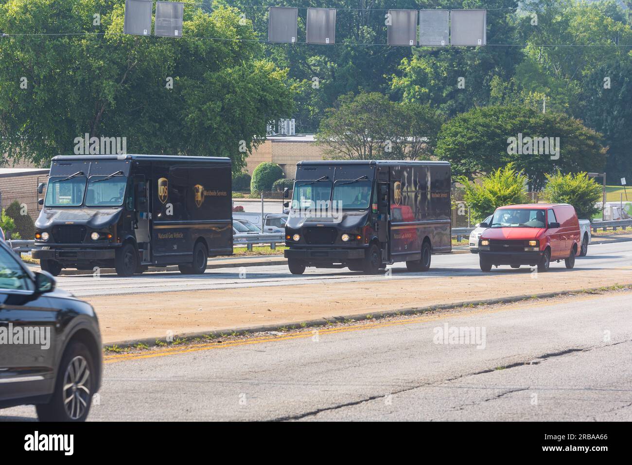 Atlanta, GA / USA – June 29, 2023: Two UPS trucks travel down a street ...