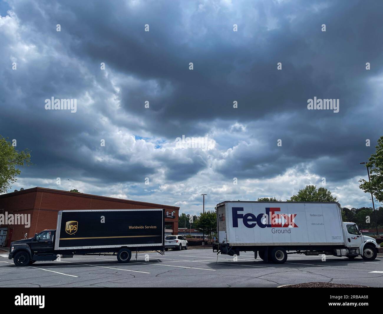Suwanee, GA / USA - May 17, 2023: A UPS and FedEx truck are parked ...