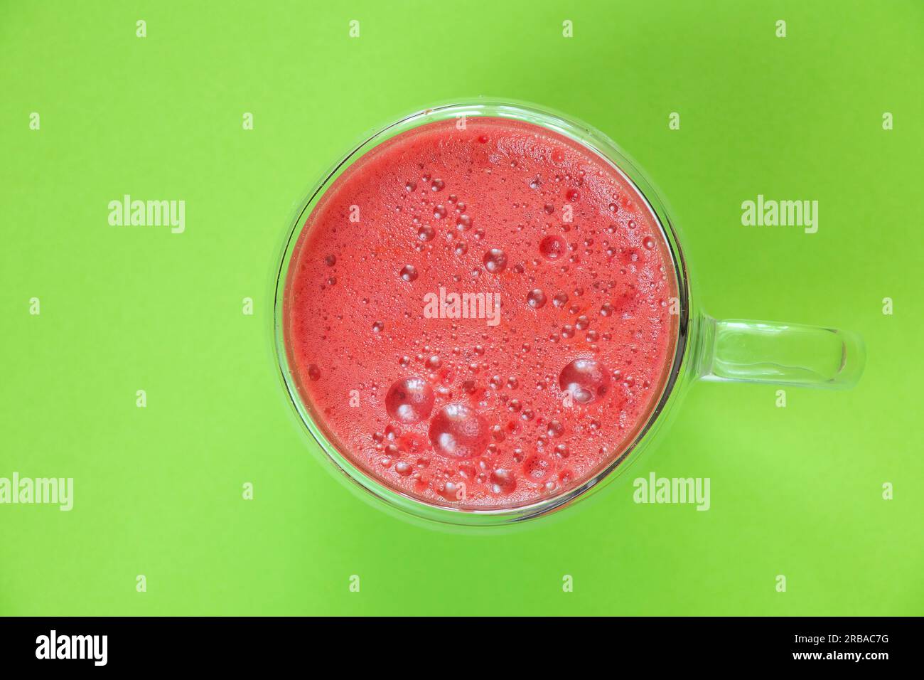 freshly squeezed red juice in a cup for breakfast with froth on top on ...