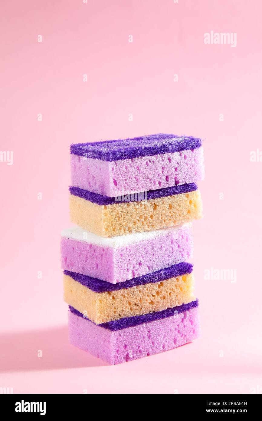 Colored sponges for washing dishes. Pink background. Stock Photo - Alamy