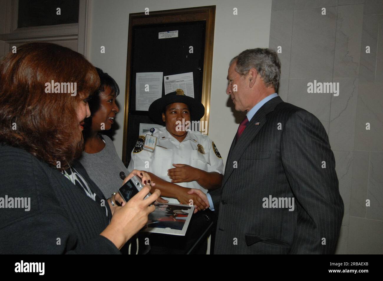 Department staff greeting President George W. Bush, from behind rope ...