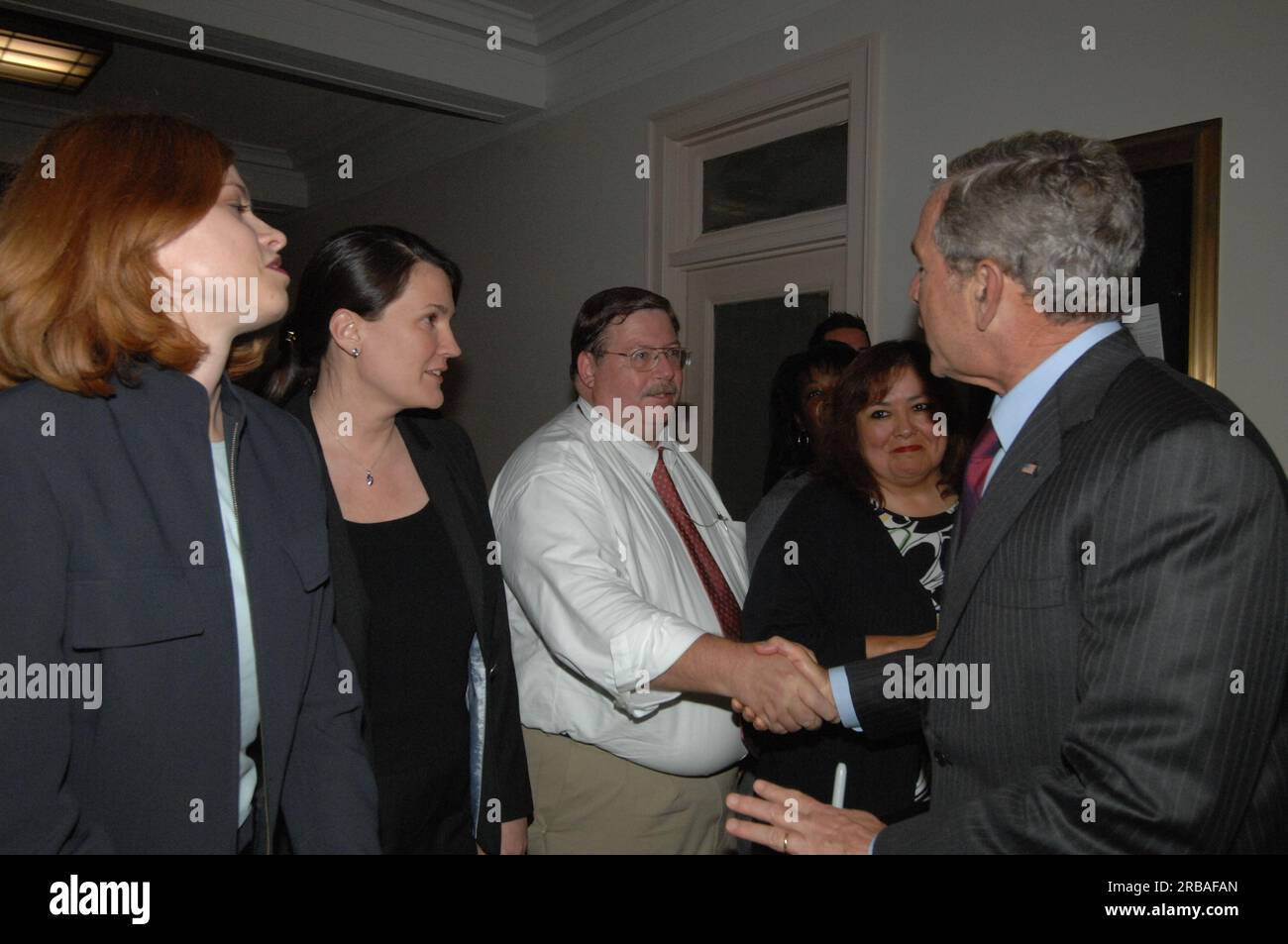 Department staff greeting President George W. Bush, from behind rope ...