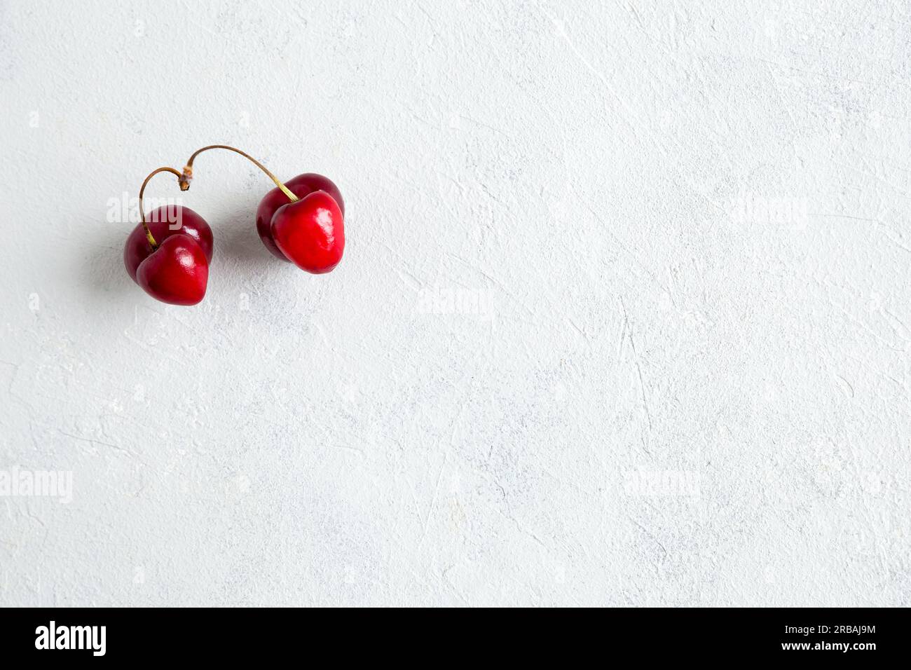 Pair of strange, ugly cherries in the heart shape on a white background ...