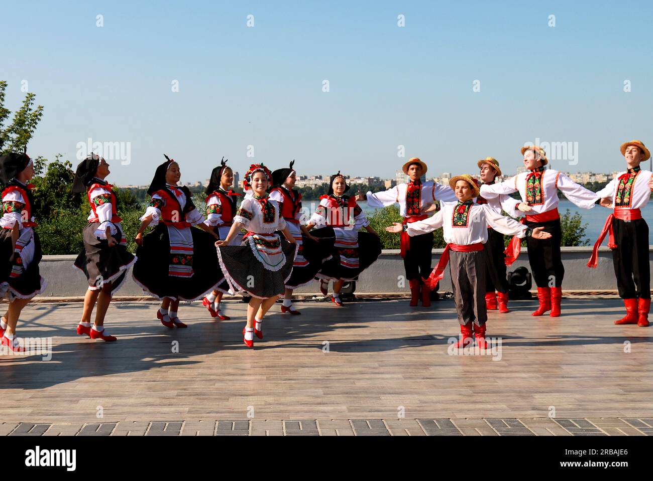 Young girls and boys dance national Ukrainian dance in folk costumes ...