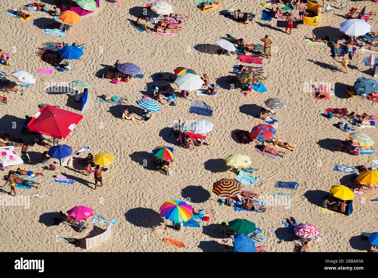 View from above of anonymous crowd, holidaymakers, colourful parasols ...
