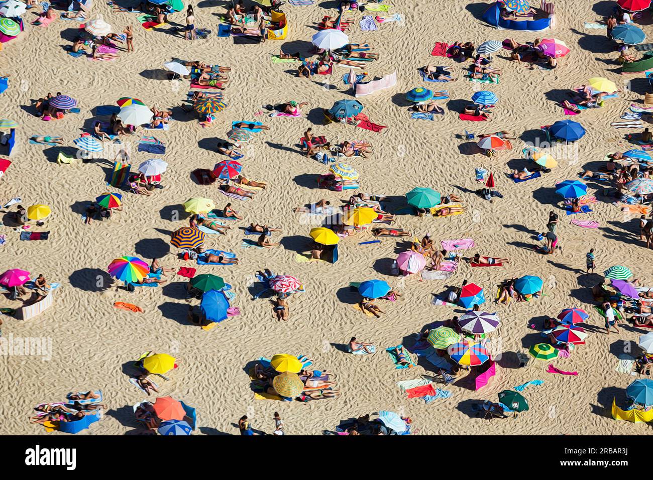 View from above of anonymous crowd, holidaymakers, colourful parasols ...
