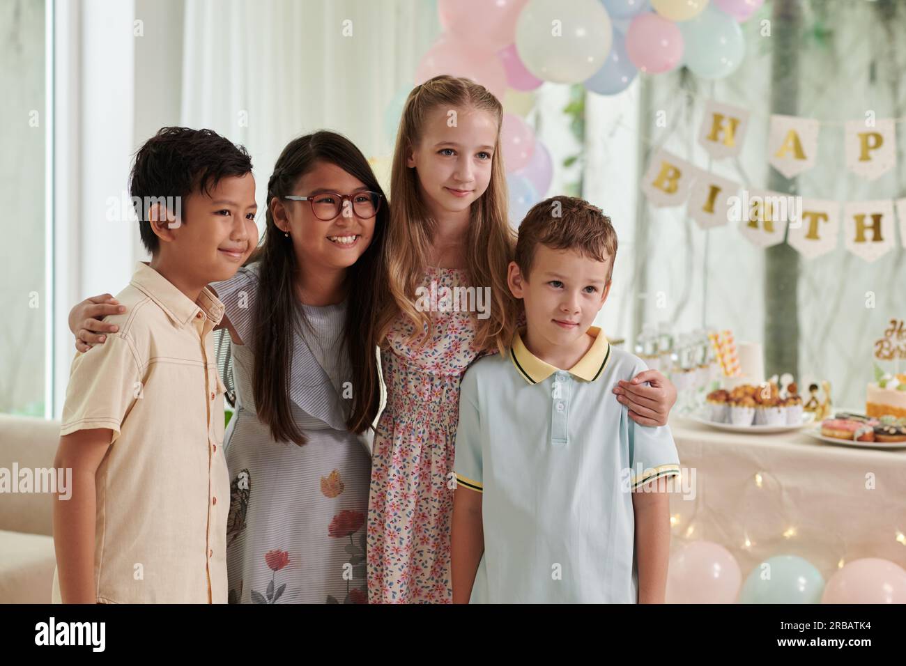 Group of children hugging when posing for photo at birthday party Stock ...