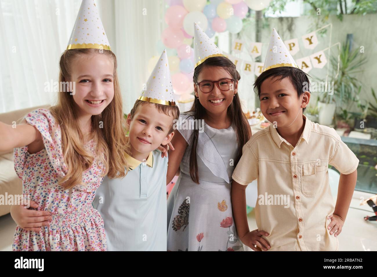 Cheerful preteen girl taking selfie with friends at birthday party ...