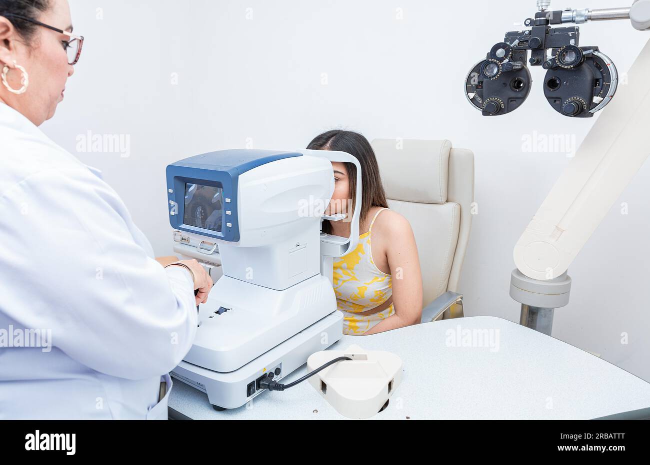 Specialist performing eye exam to female patient. Optometrist checking ...