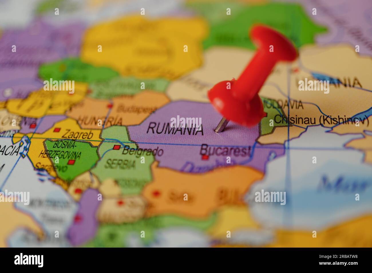 Romania marked with a red thumbtack on a map with an out-of-focus ...