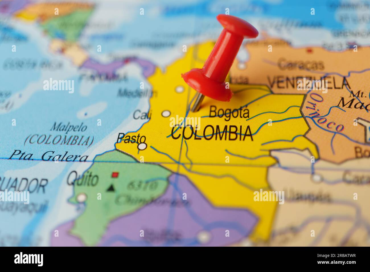 Colombia marked with a red thumbtack on a map with an out-of-focus ...