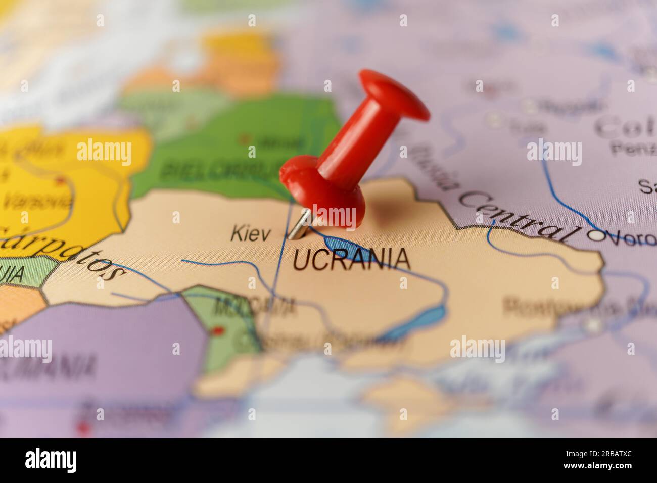 Ukraine marked with a red thumbtack on a map with an out-of-focus ...