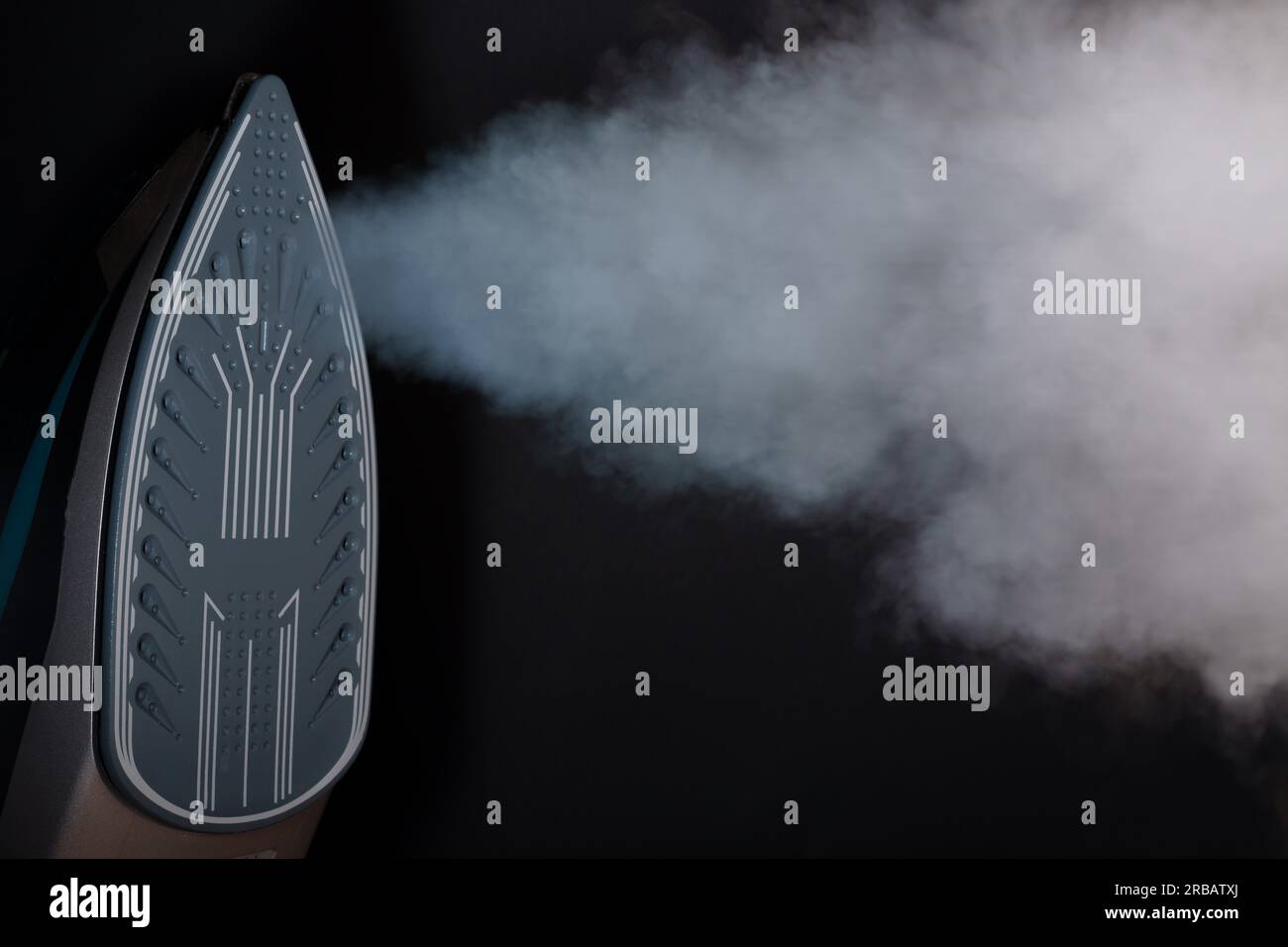 Iron seen from the front with steam coming out of its orifices on a ...