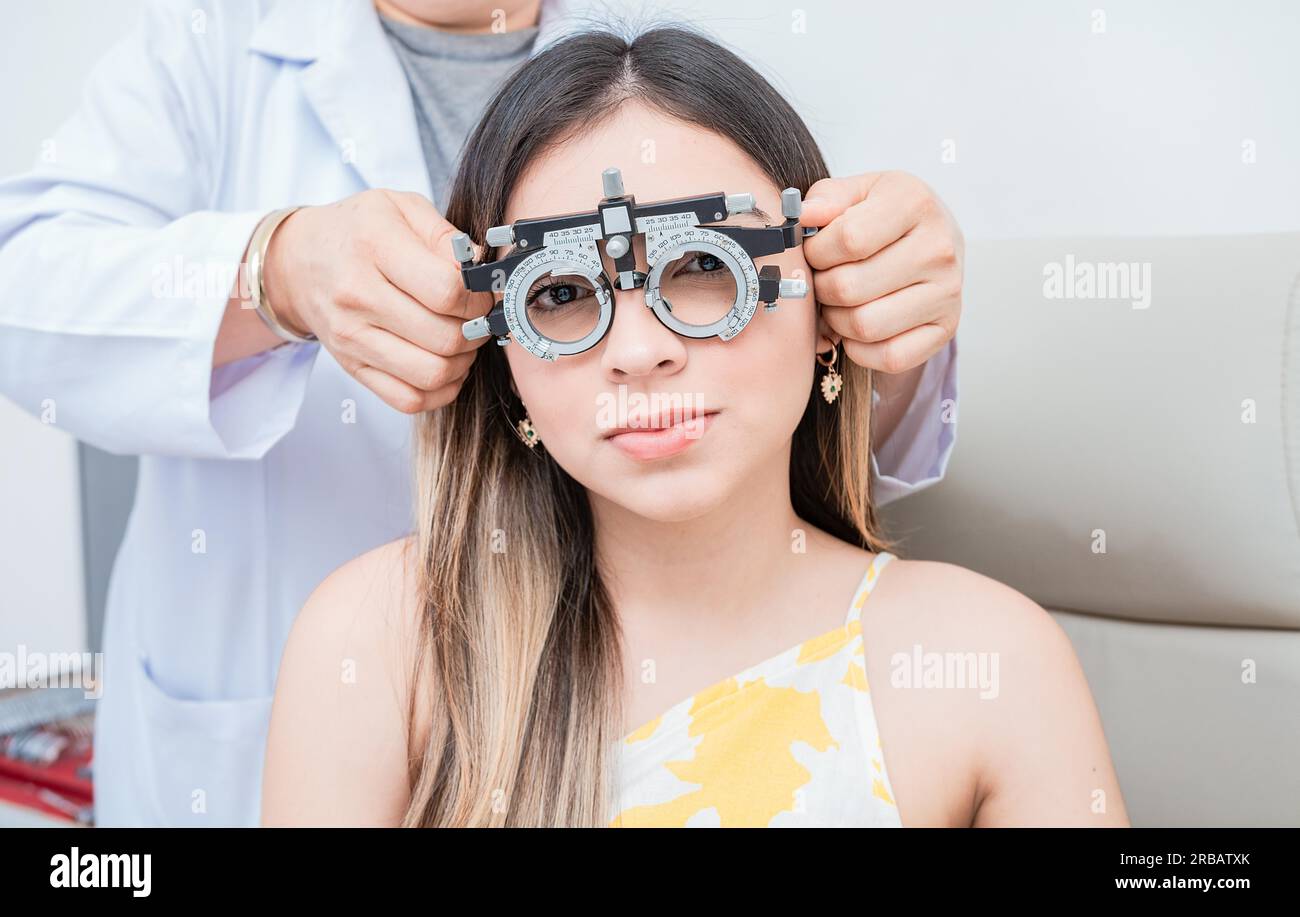 Hands of optometrist examining patient with optometrist trial frame ... Hands of optometrist examining patient with optometrist trial frame ...