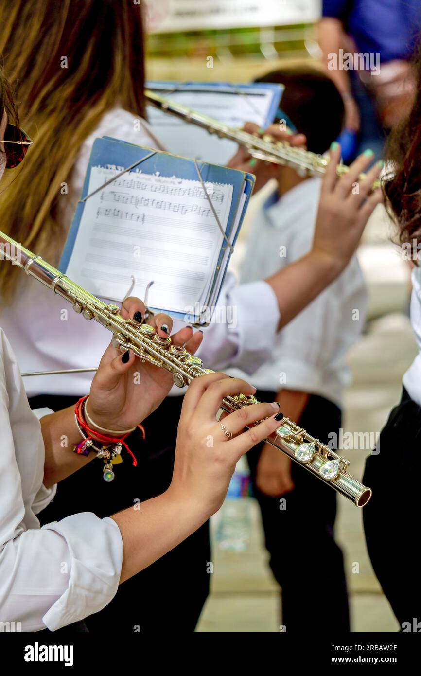 Woman's hands playing a transverse flute with sheet music in the ...