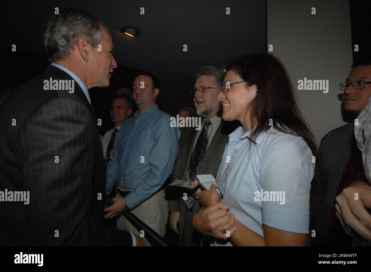 Department staff greeting President George W. Bush, from behind rope ...