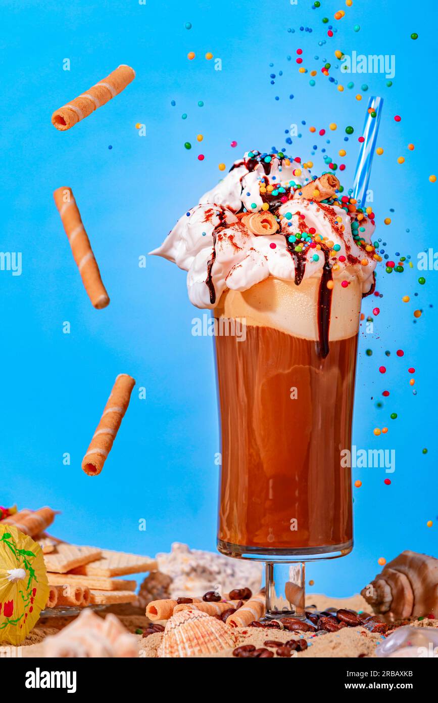 Iced coffee with whipped cream, chocolate sauce and flying sugar ...