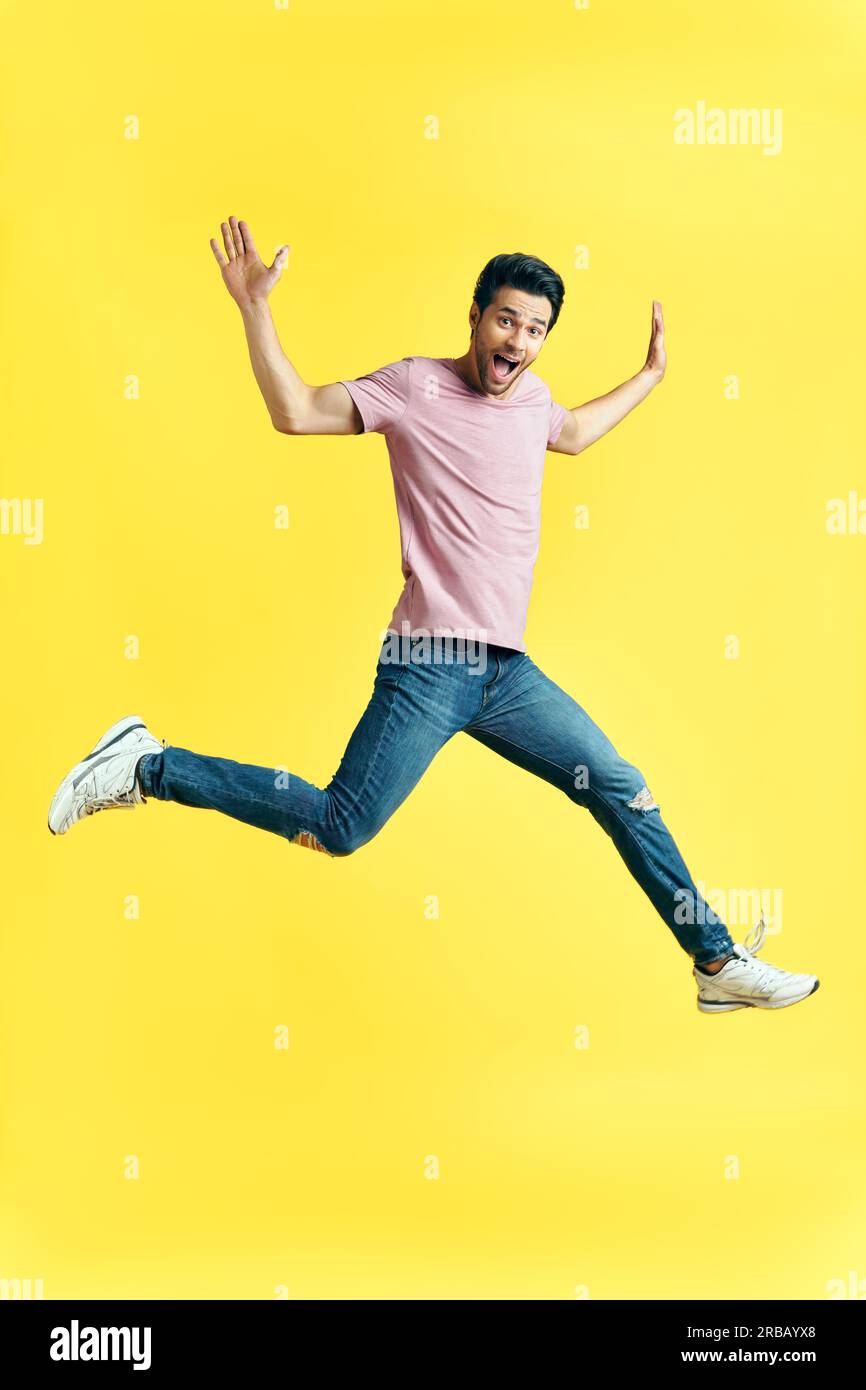 Happy excited man jumping on yellow background. carefree and fun ...