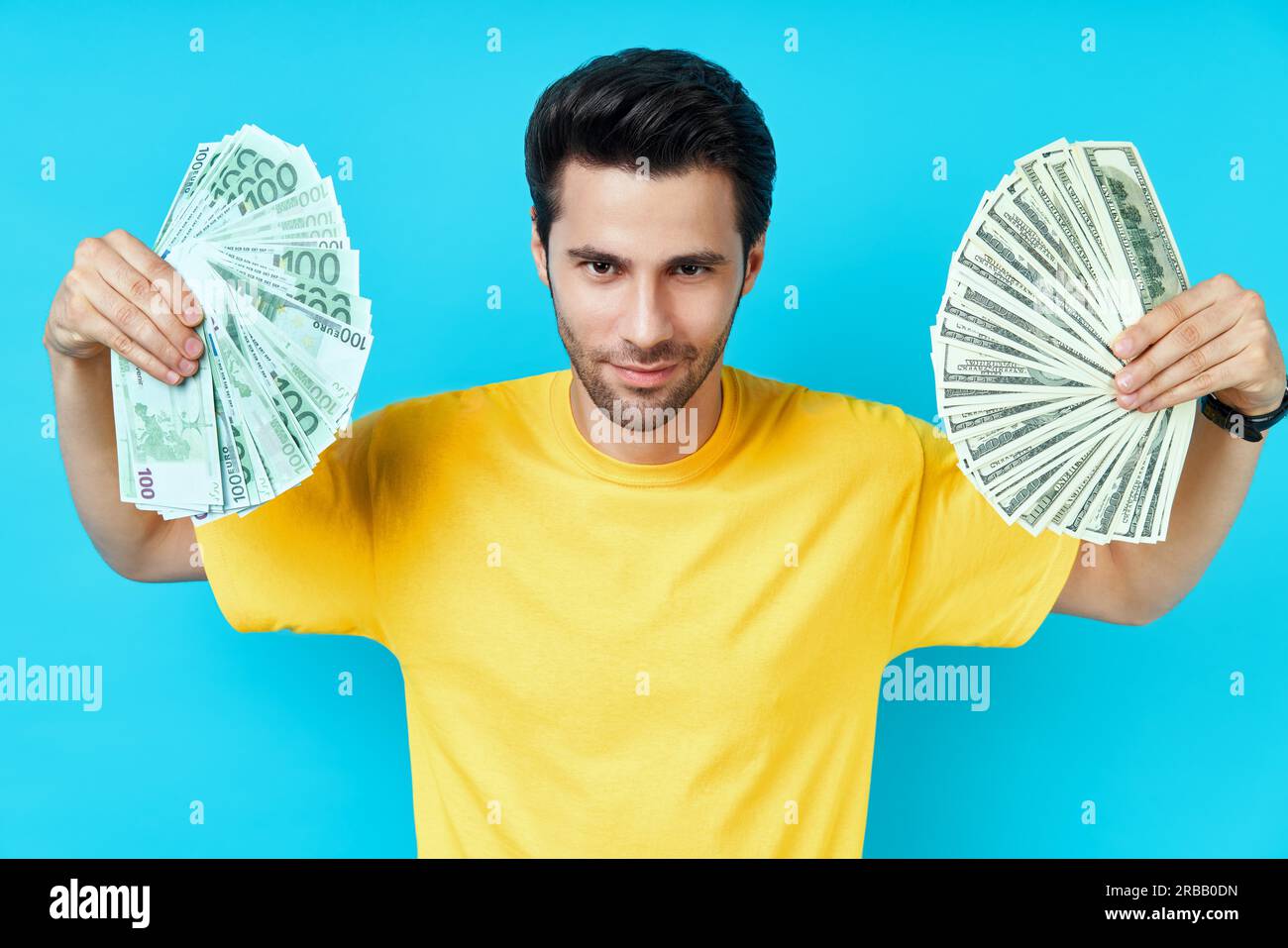 Happy smiling man holding money banknotes on blue background. Business ...