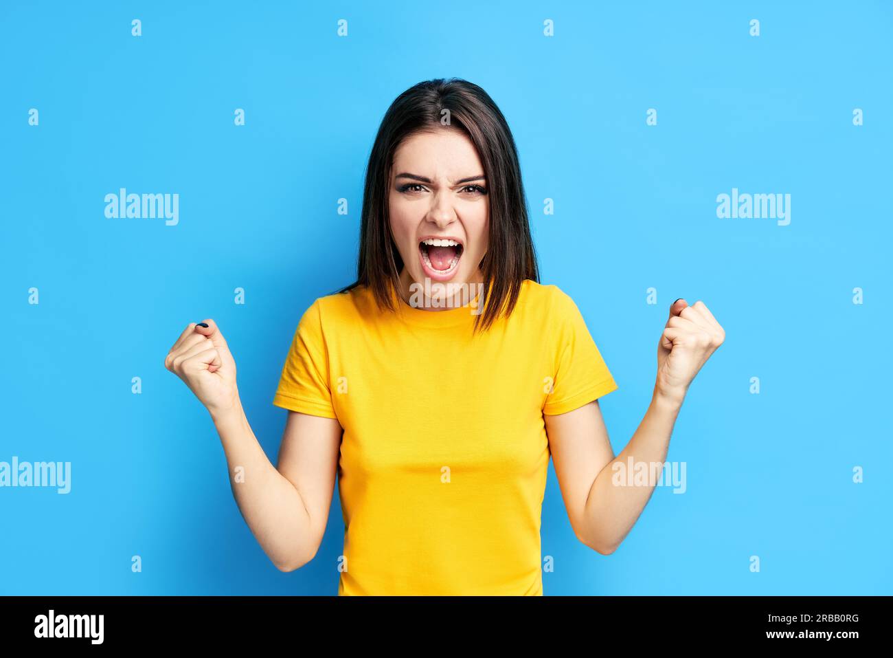 Screaming emotional angry young woman on blue background. Negative ...