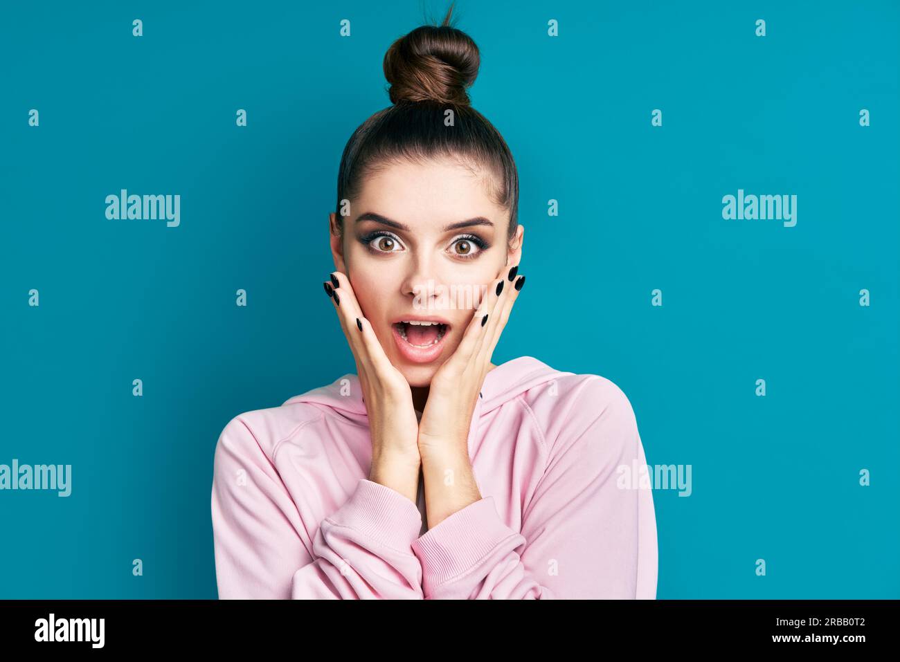 Portrait of surprised happy woman over blue backround. Wow concept ...