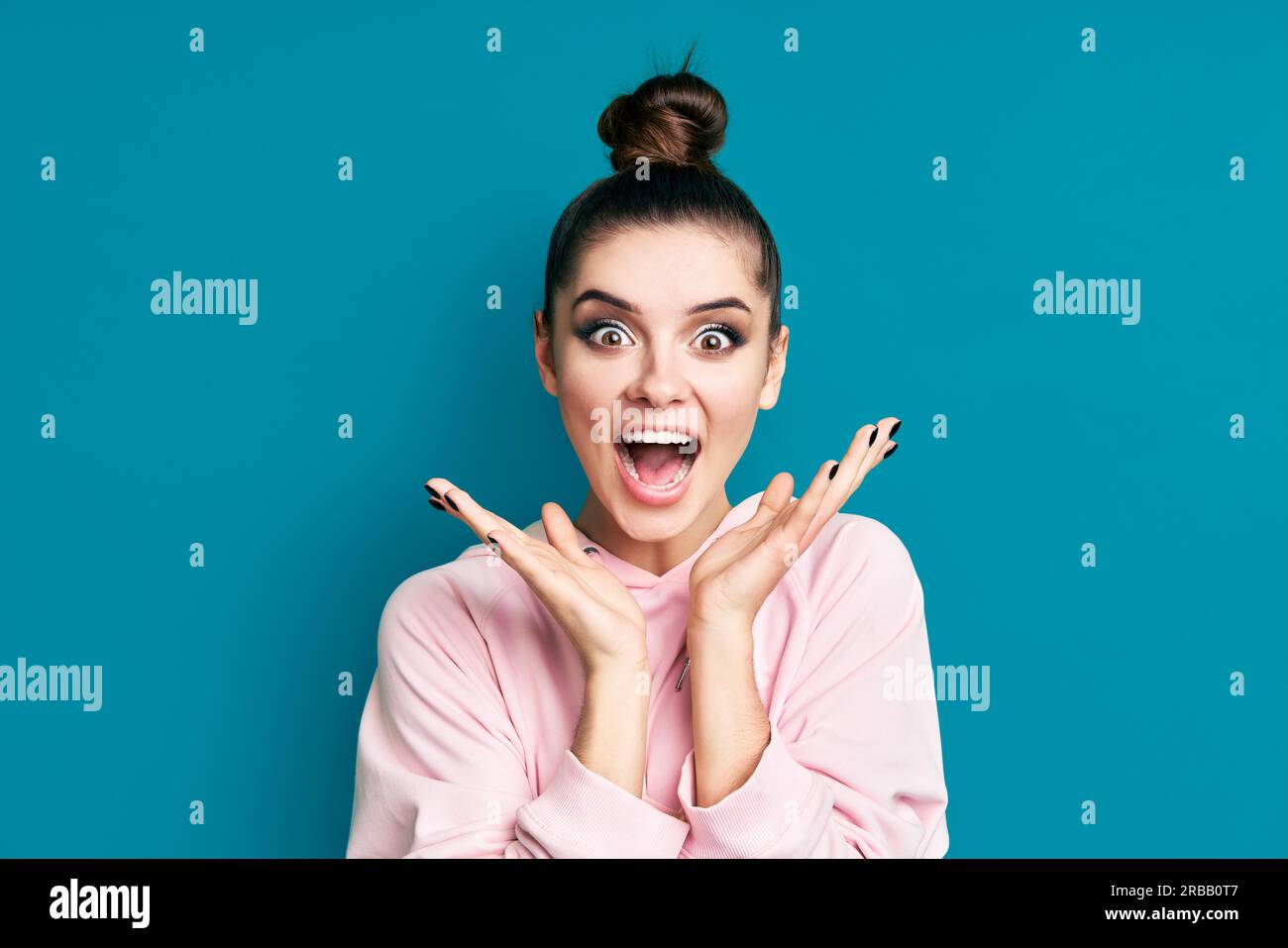 Portrait of surprised happy woman over blue backround. Wow concept ...