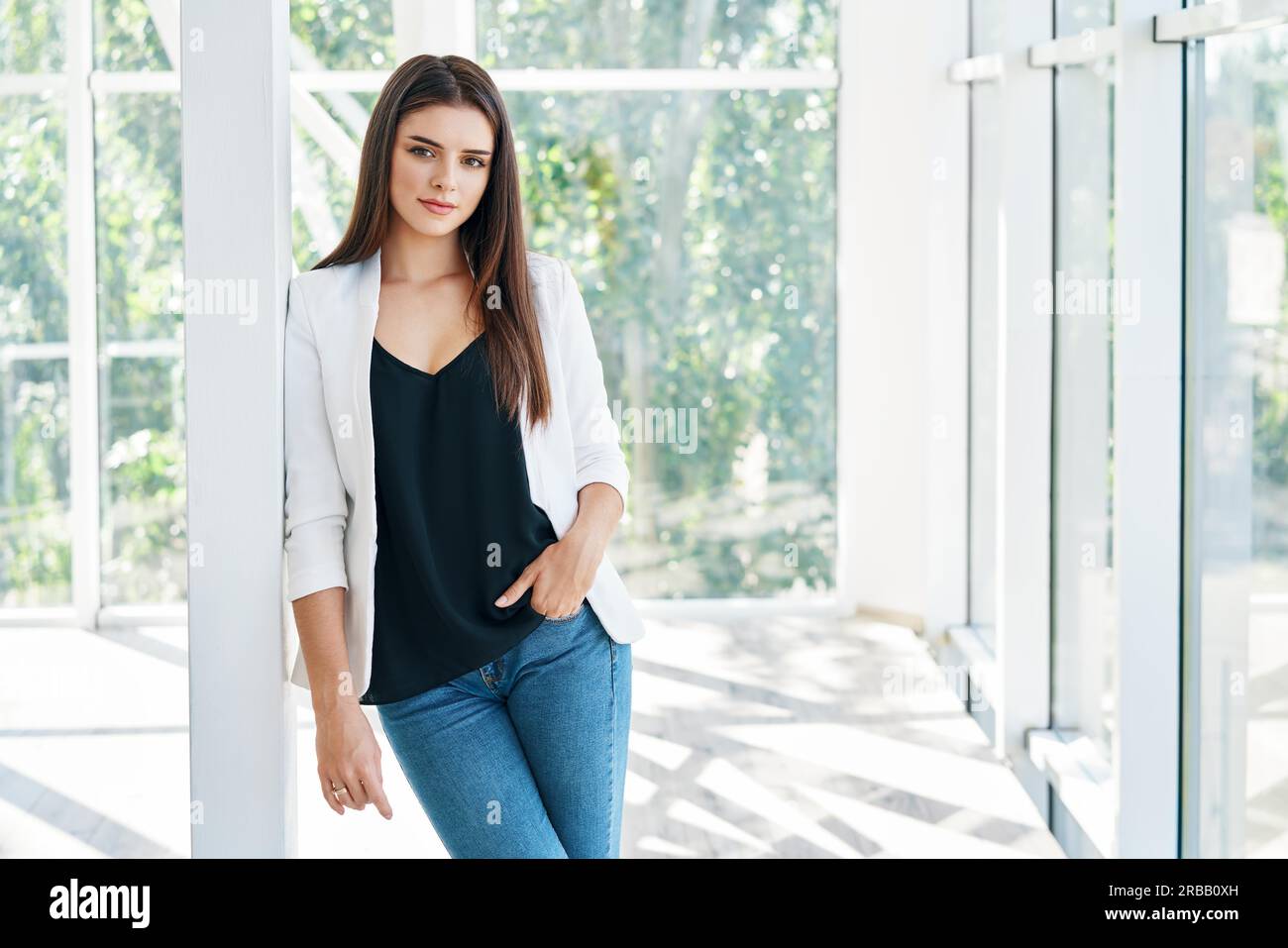 Smiling pretty business woman posing in a modern office with panoramic ...