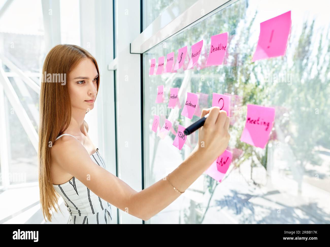 Attractive concentrated business woman using sticky notes to write and ...