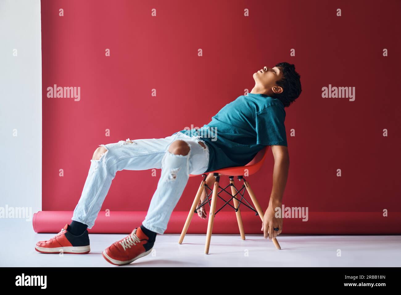 Portrait of tired young man sitting on chair in studio. Emotions ...