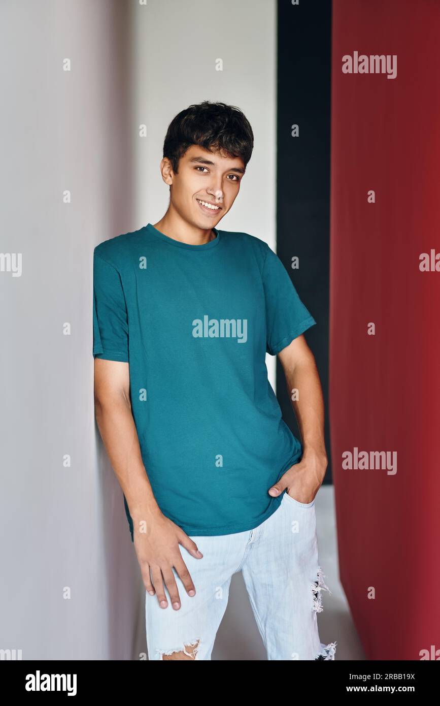 Young smiling handsome man posing on studio background looking to ...